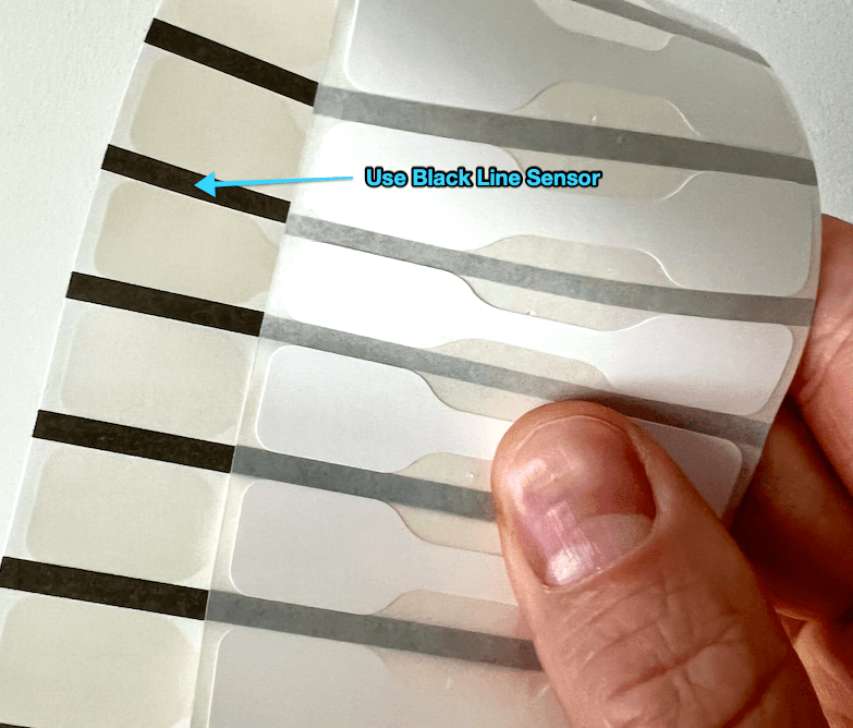 The black-line sensor also works to detect holes in the label where the ...